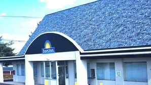 Um Days Inn com telhado azul, uma placa visível e um sinal de estacionamento indicando um aeroporto regional.