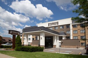 Um hotel Staybridge Suites com entrada coberta e estacionamento.