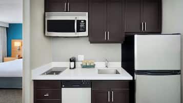 Um frigorífico/congelador grande, um micro-ondas, uma placa de cozinha