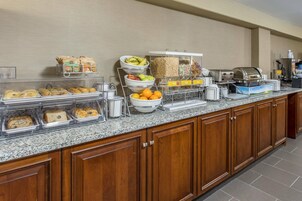Área de buffet com diversas opções de comida e um espaço para café.