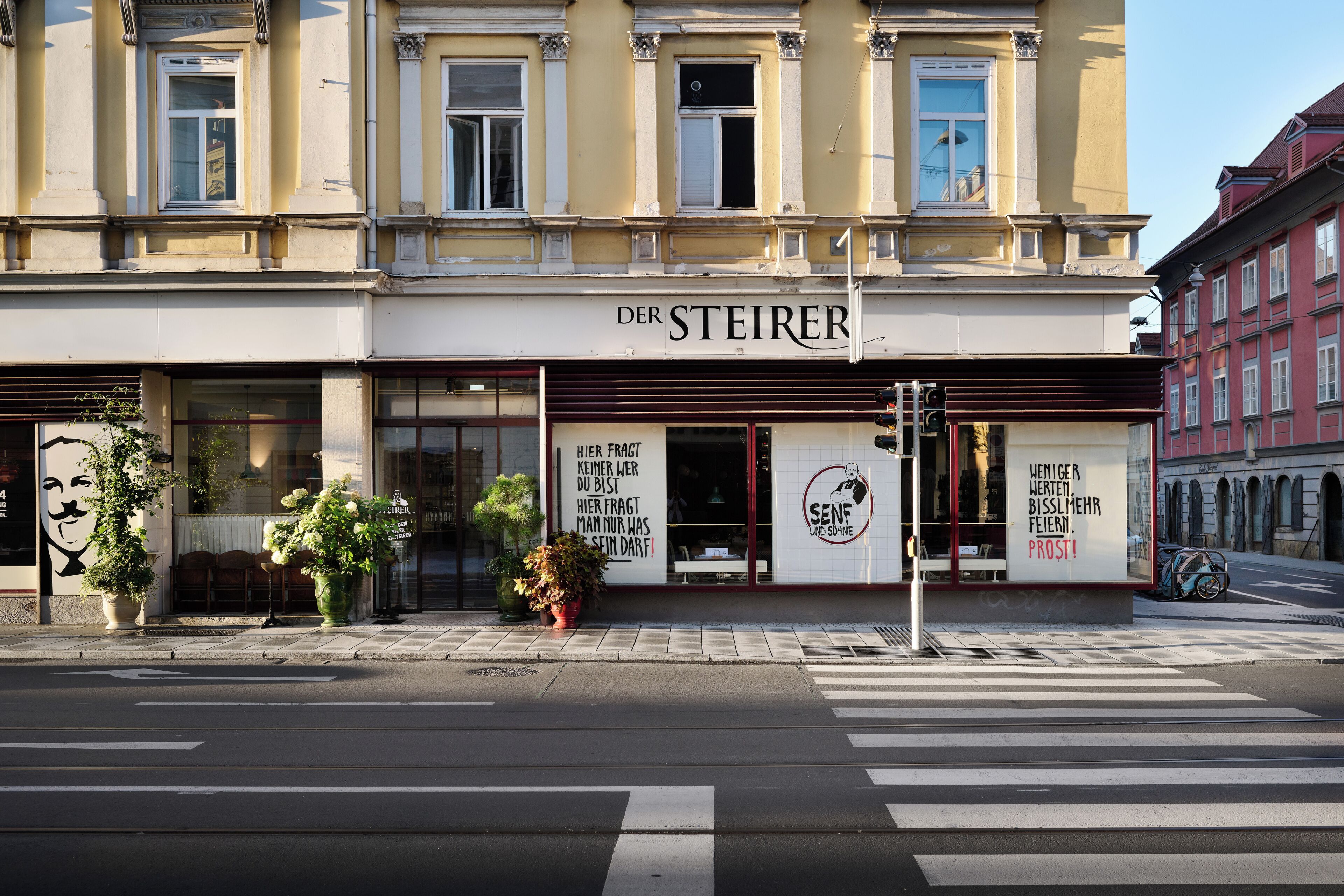 Um edifício com uma placa com a inscrição 'DER STEIERER' e um amplo vitrine.