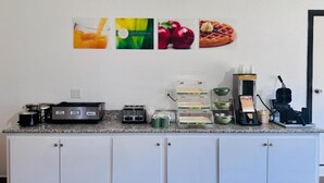 Uma bancada de cozinha com cafeteira, torradeira e diversos utensílios.