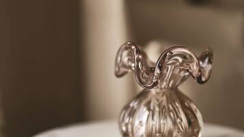 Um vaso de vidro transparente sobre uma mesa de mármore.