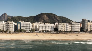 Na praia, praia de areia branca, espreguiçadeiras, toalhas de praia