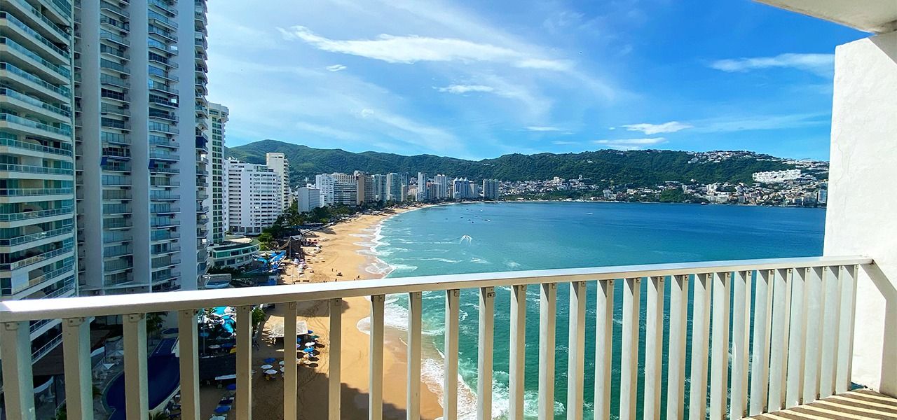 Uma varanda com vista para a praia e edifícios altos.