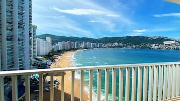 Uma varanda com vista para a praia e edifícios altos.