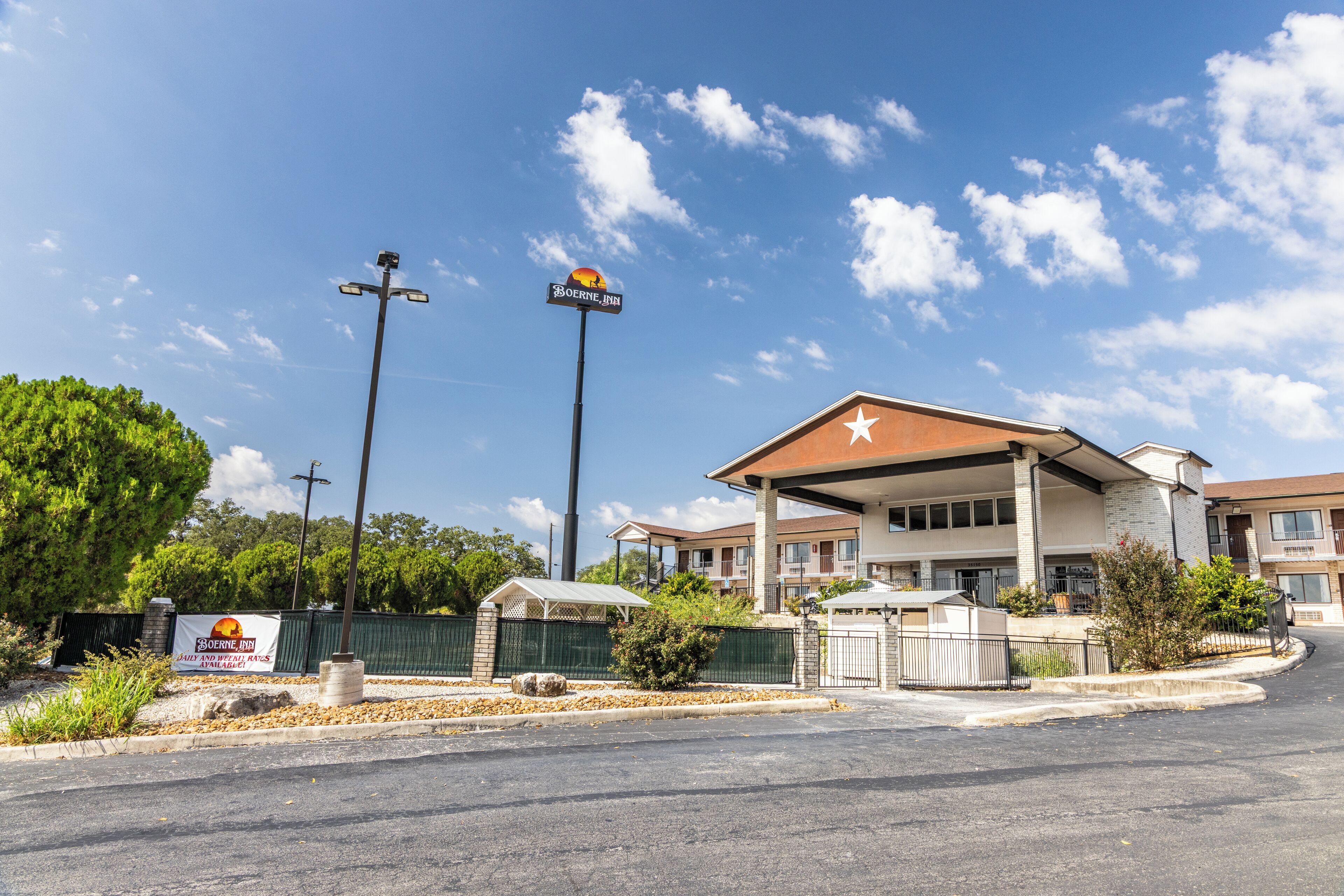 Um hotel com posto de gasolina, estacionamento e um céu azul límpido.