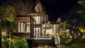 Uma villa moderna com piscina, vários níveis e paisagismo tropical.