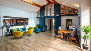 Um loft espaçoso com pé direito alto, área de jantar e cozinha.