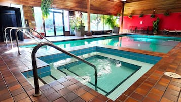 Piscina interna com piso ladrilhado, escada metálica e plantas em vasos.