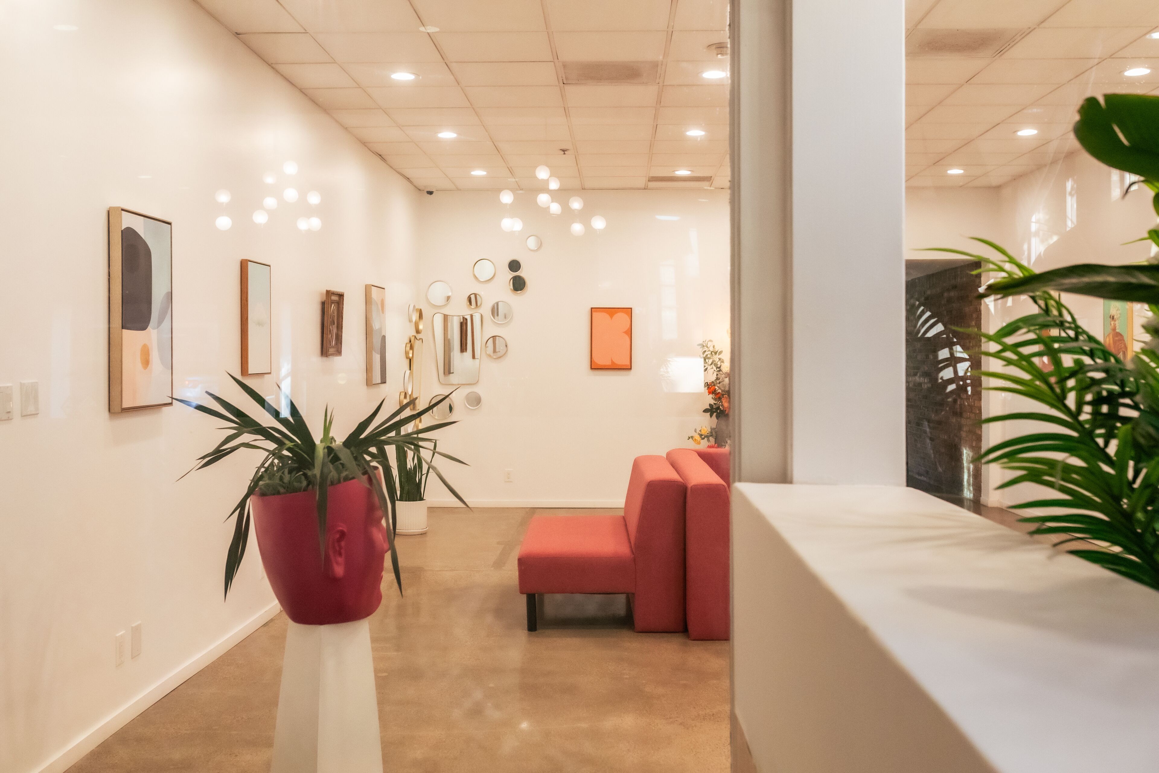 Um interior moderno com balcão de recepção, área de estar e obras de arte nas paredes.