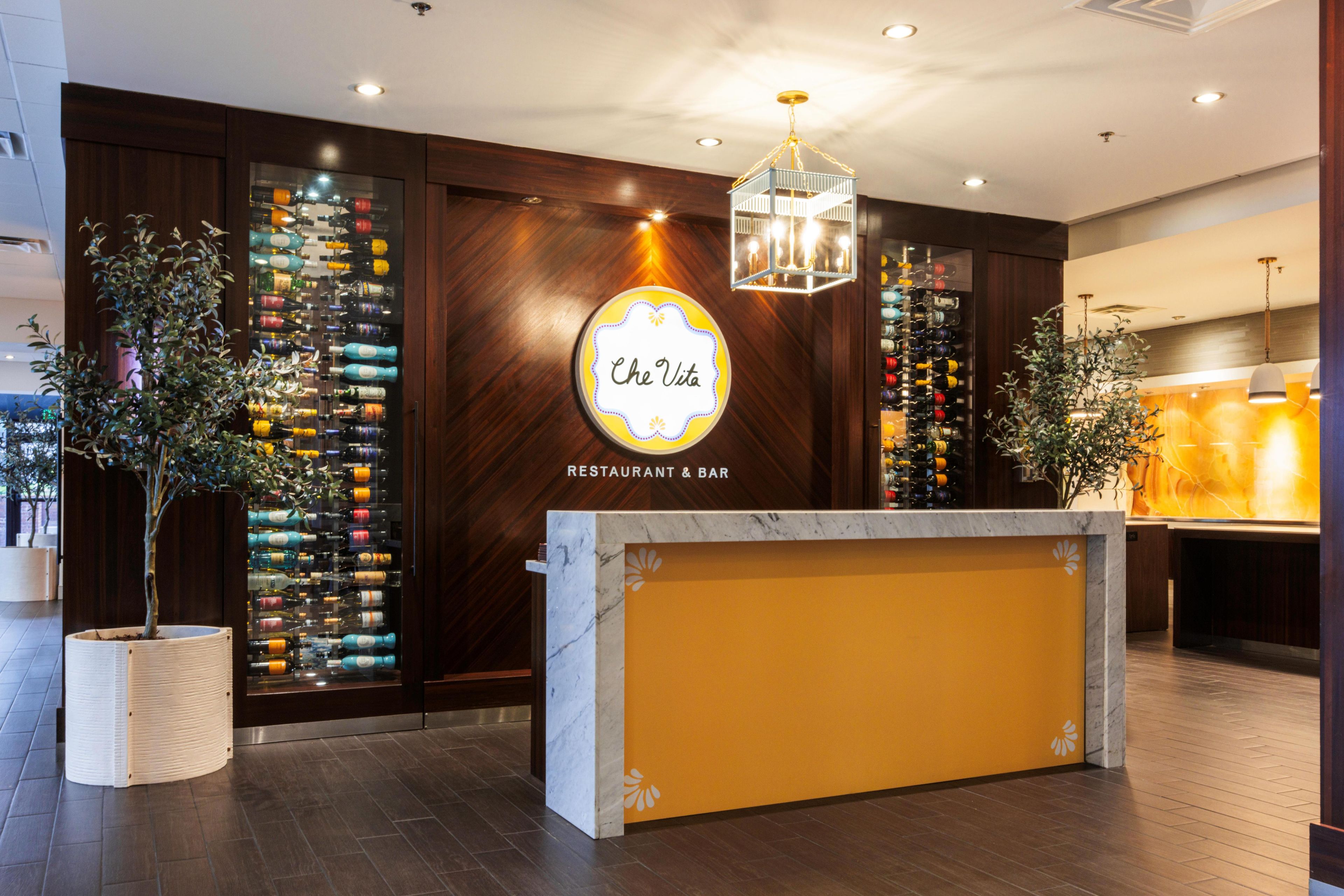 Restaurante e bar com parede de madeira, uma placa circular e um balcão de recepção.
