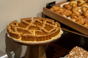 Uma torta com cobertura treliçada sobre um suporte de madeira.