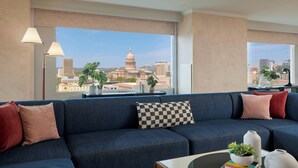 Sala de estar moderna com uma janela ampla que oferece vista para a cidade, incluindo um edifício imponente.