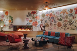 Uma sala de estar moderna com sofá, poltronas, mesa de centro e lareira.