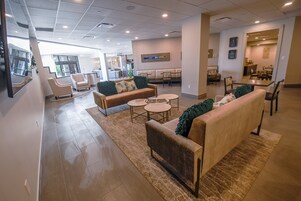 Um lobby amplo com áreas de estar, balcão de recepção e sala de jantar.