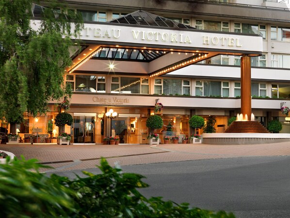 Hotel Chateau Victoria com entrada imponente, área de estar ao ar livre e uma fonte central.