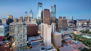 Paisagem urbana com diversos edifícios altos, incluindo um arranha-céu imponente e design singular.