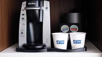 Uma cafeteira Keurig com duas chávenas descartáveis numa bandeja, um botão de energia e um botão 'Brew'.