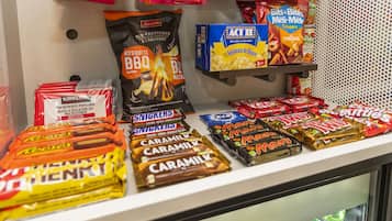 Exposição de snacks com diversas marcas como Snickers, Milky Way e M&M's.