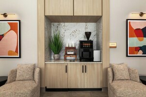 Cozinha moderna com máquina de café, uma planta e uma pequena mesa com xícaras.