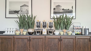 Um espaço com café, duas máquinas de expresso, um dispensador de café e um suporte para chávenas.