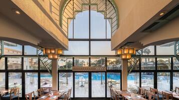 Restaurante com vista para uma piscina e mesas ao ar livre.