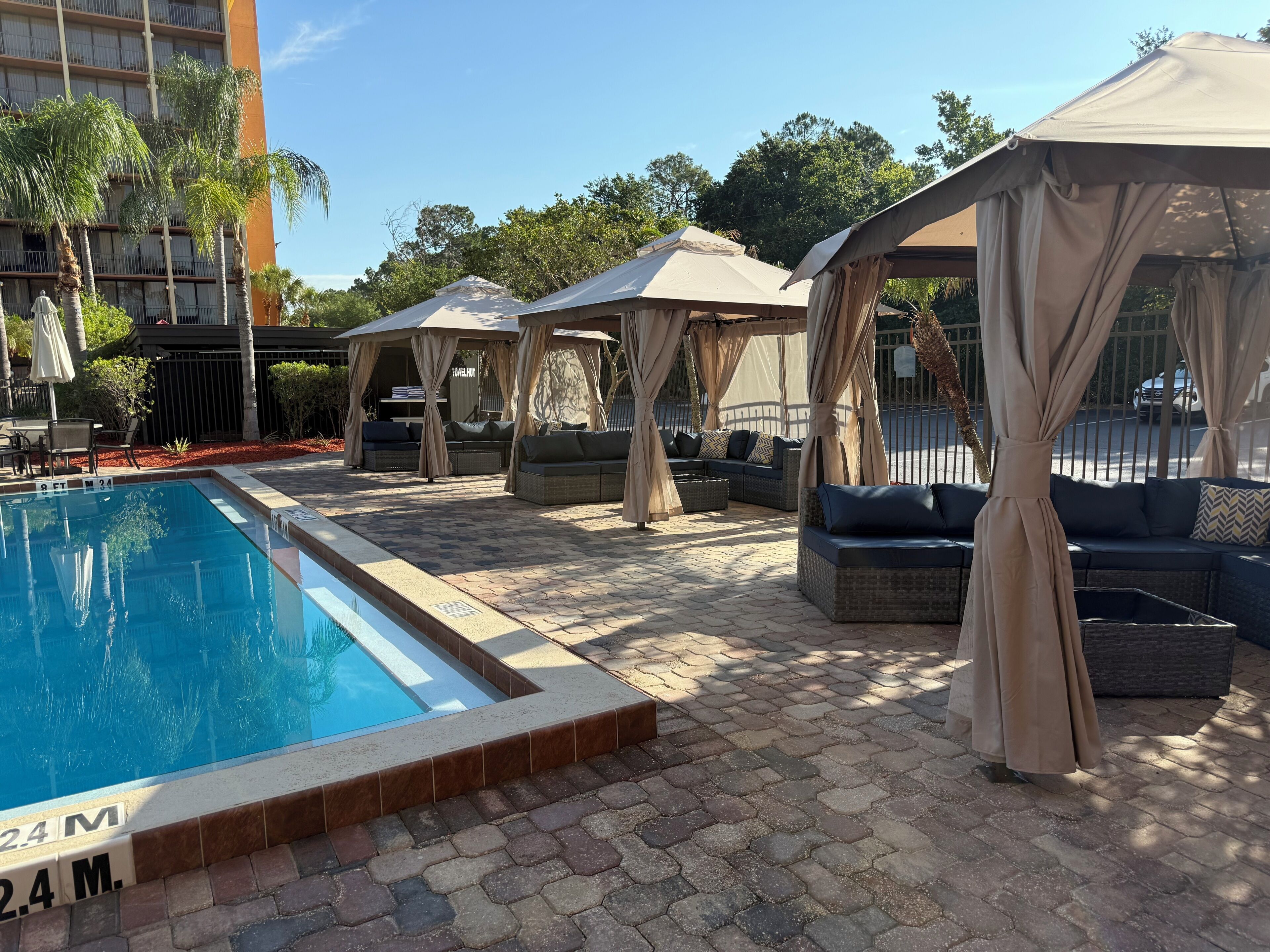 Uma área de piscina com piscina, mobiliário de exterior e estruturas cobertas.