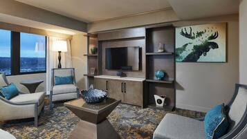 Quarto de hotel moderno com uma janela grande, televisão de tela plana, lareira e vista para a cidade.