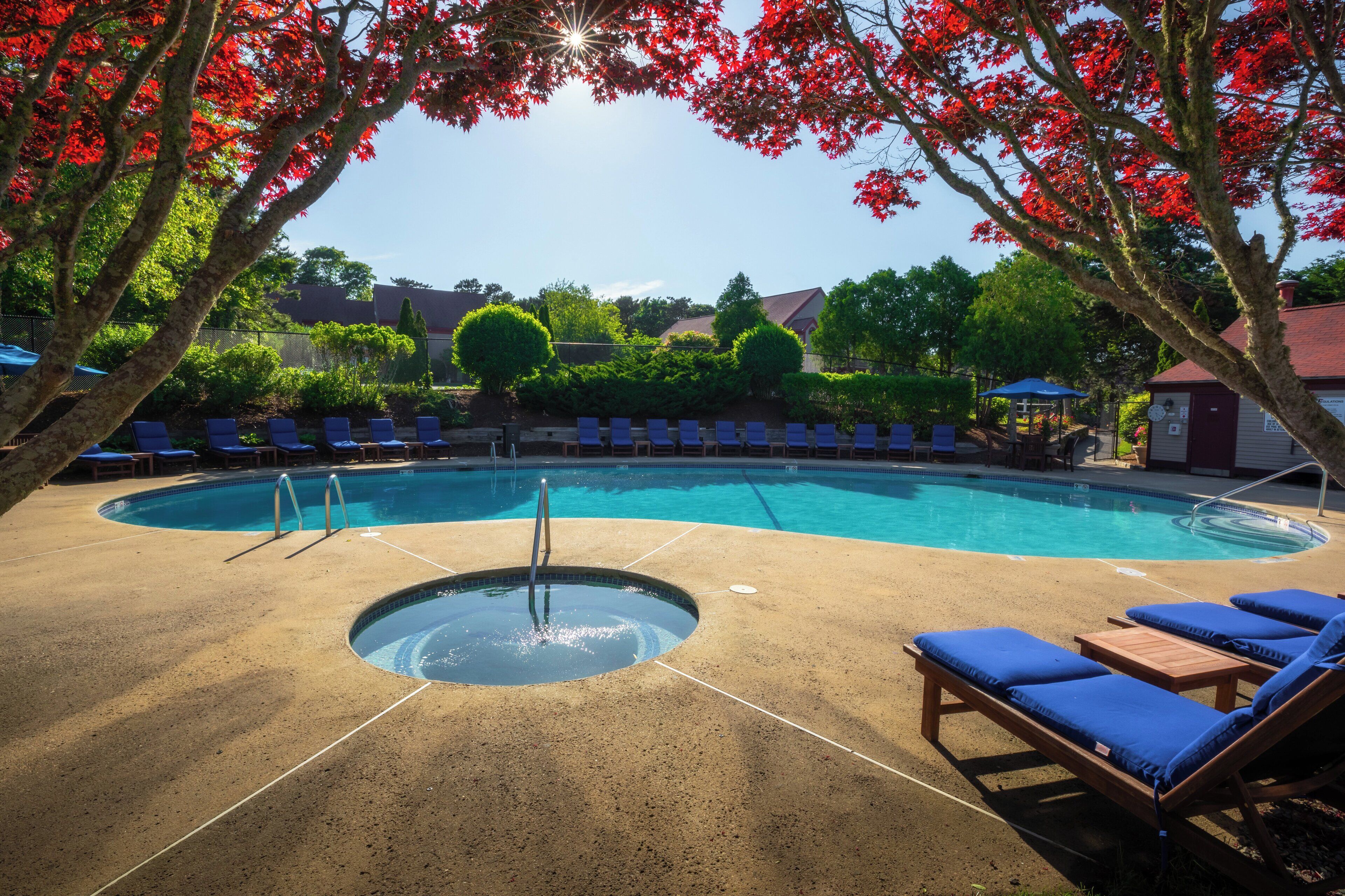 Piscina com espreguiçadeiras e banheira de hidromassagem.