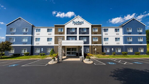 Um hotel Fairfield by Marriott com entrada central, vários andares e estacionamento com vagas para deficientes.