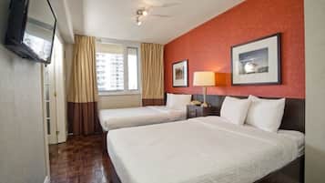 Quarto de hotel com duas camas, televisão, janela com cortinas e um quadro na parede.