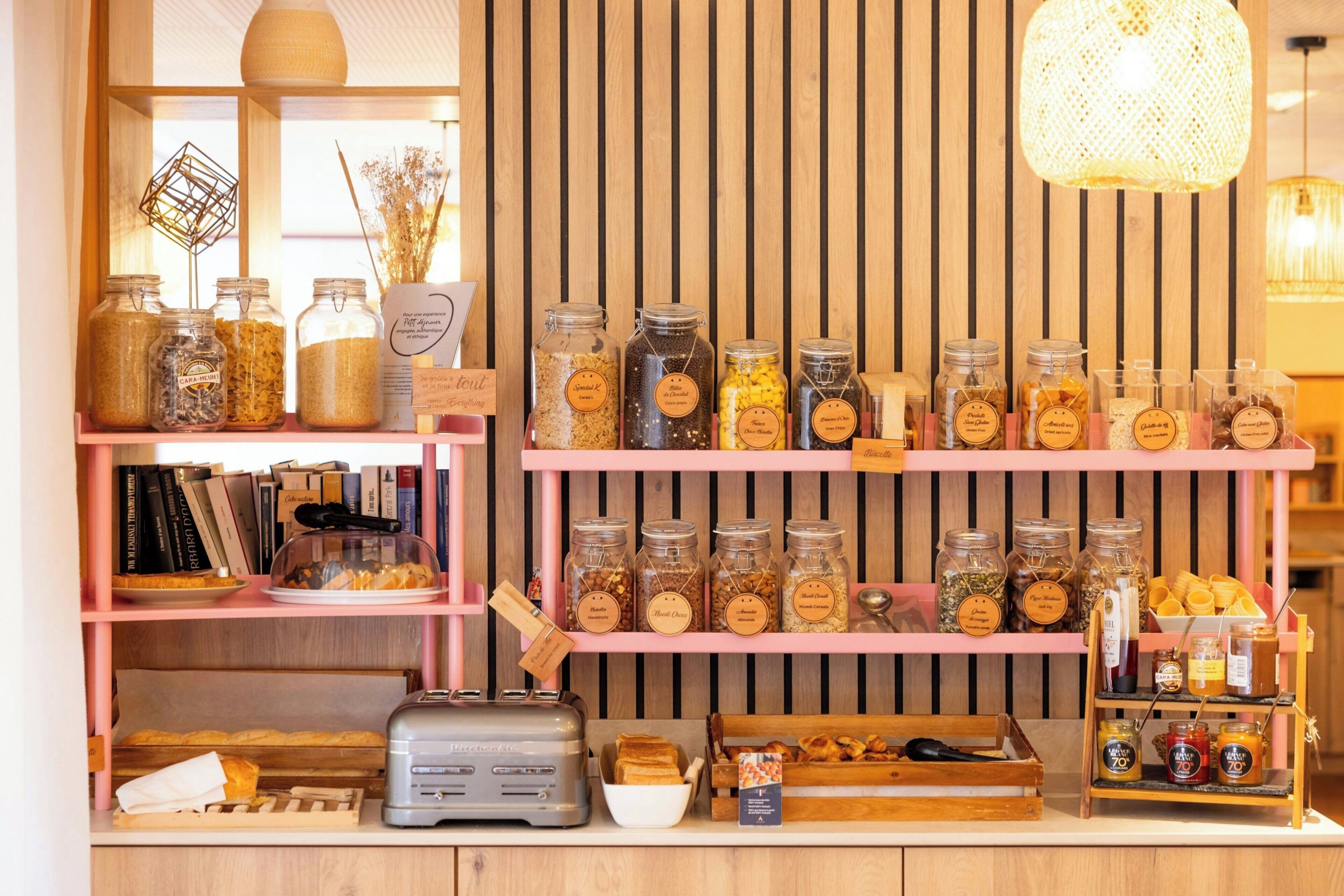 Vitrine de pastelaria com vários potes de produtos de panificação e uma torradeira.