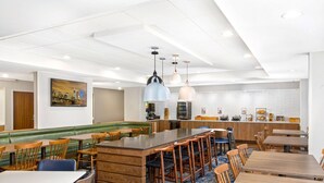 Restaurante moderno com balcão central, cabines e banquetas.