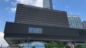 Um edifício moderno com um telhado inclinado e uma fachada retangular imponente.