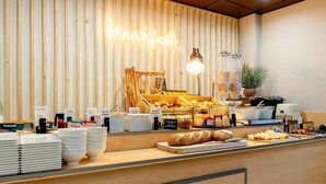 Um buffet de café da manhã com diversos alimentos e um letreiro neon.