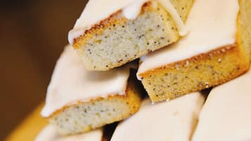 Uma pilha de doces retangulares com cobertura cremosa.