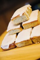 Uma pilha de doces retangulares com cobertura cremosa.