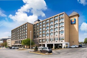 Um hotel Comfort Inn com design moderno, apresentando um amplo estacionamento e vários carros estacionados na frente.