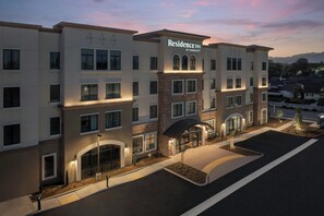 Um hotel com vários andares e design moderno, com uma entrada destacada, área coberta e placa indicando ser um Marriott Residence Inn.
