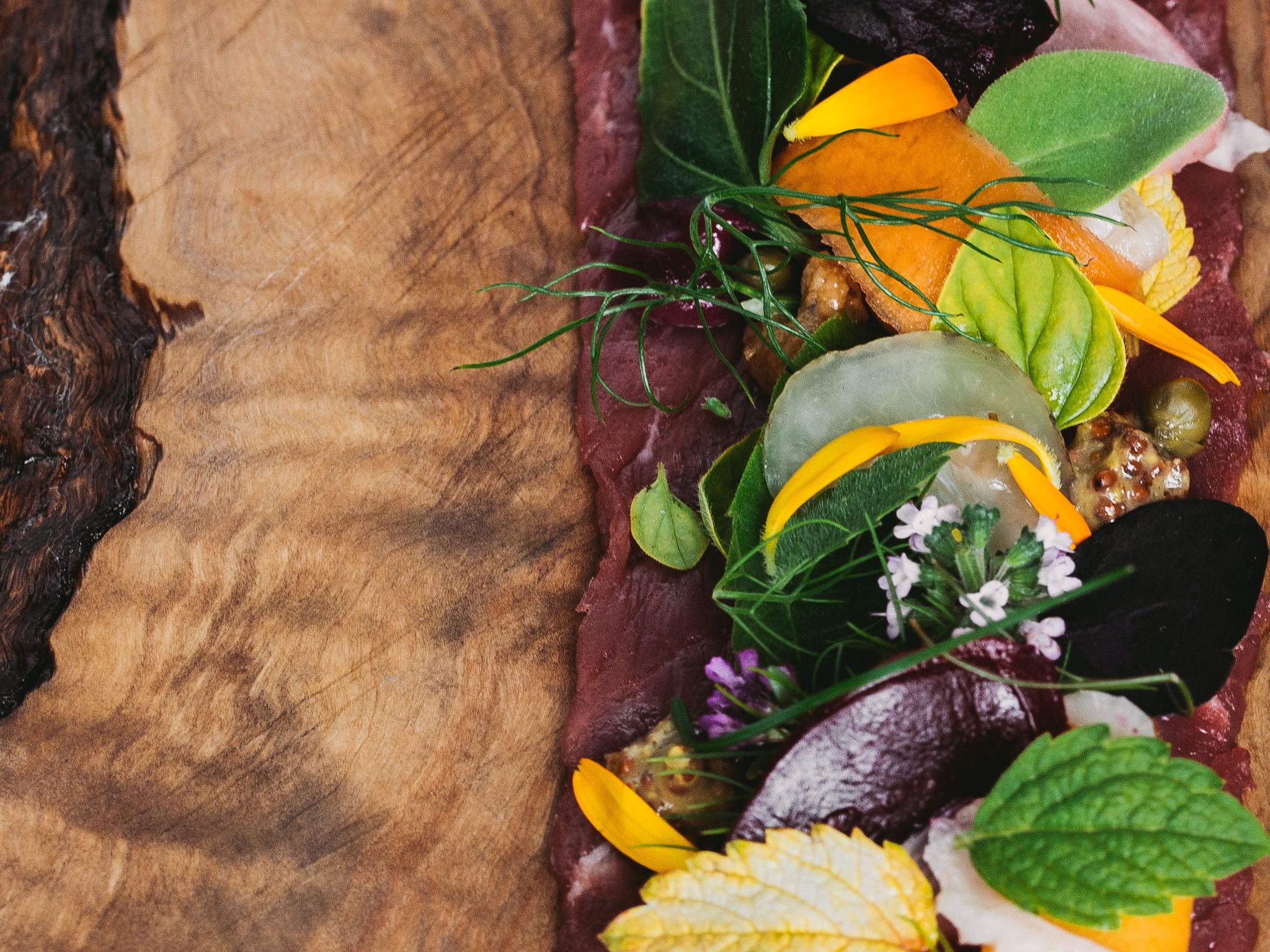 Uma mesa de madeira com diversos alimentos e guarnições.
