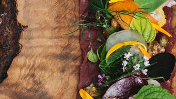 Uma mesa de madeira com diversos alimentos e guarnições.