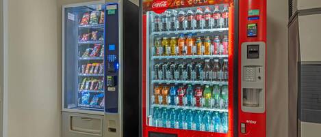 Duas máquinas de venda automática, uma com o logotipo da Coca-Cola e outra com opção de 60% menos açúcar.