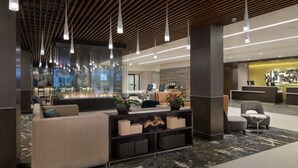 Um lobby moderno com balcão de recepção, área de estar e um grande aquário.