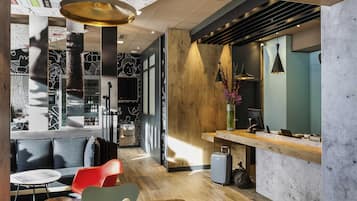 Um interior moderno com piso de madeira, área de bar e espaço de estar com uma cadeira vermelha.