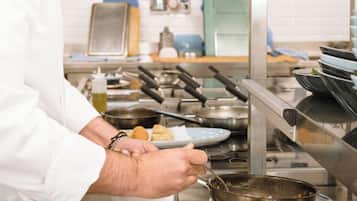 Um chefe de cozinha em uma cozinha profissional, com equipamentos e utensílios de aço inoxidável.