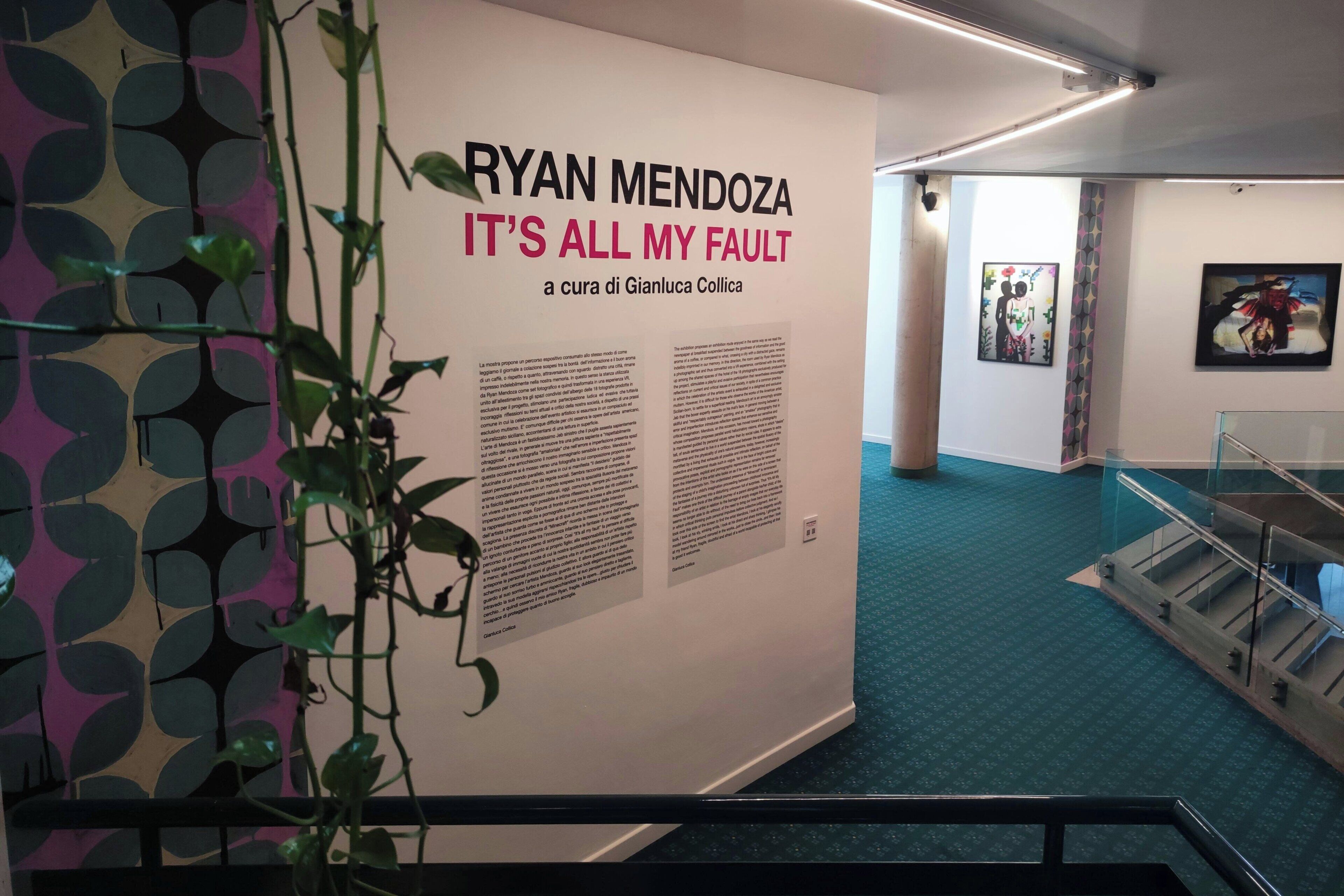 Um espaço interno com uma parede exibindo texto e um cartaz, uma escada e uma parede com padrão.