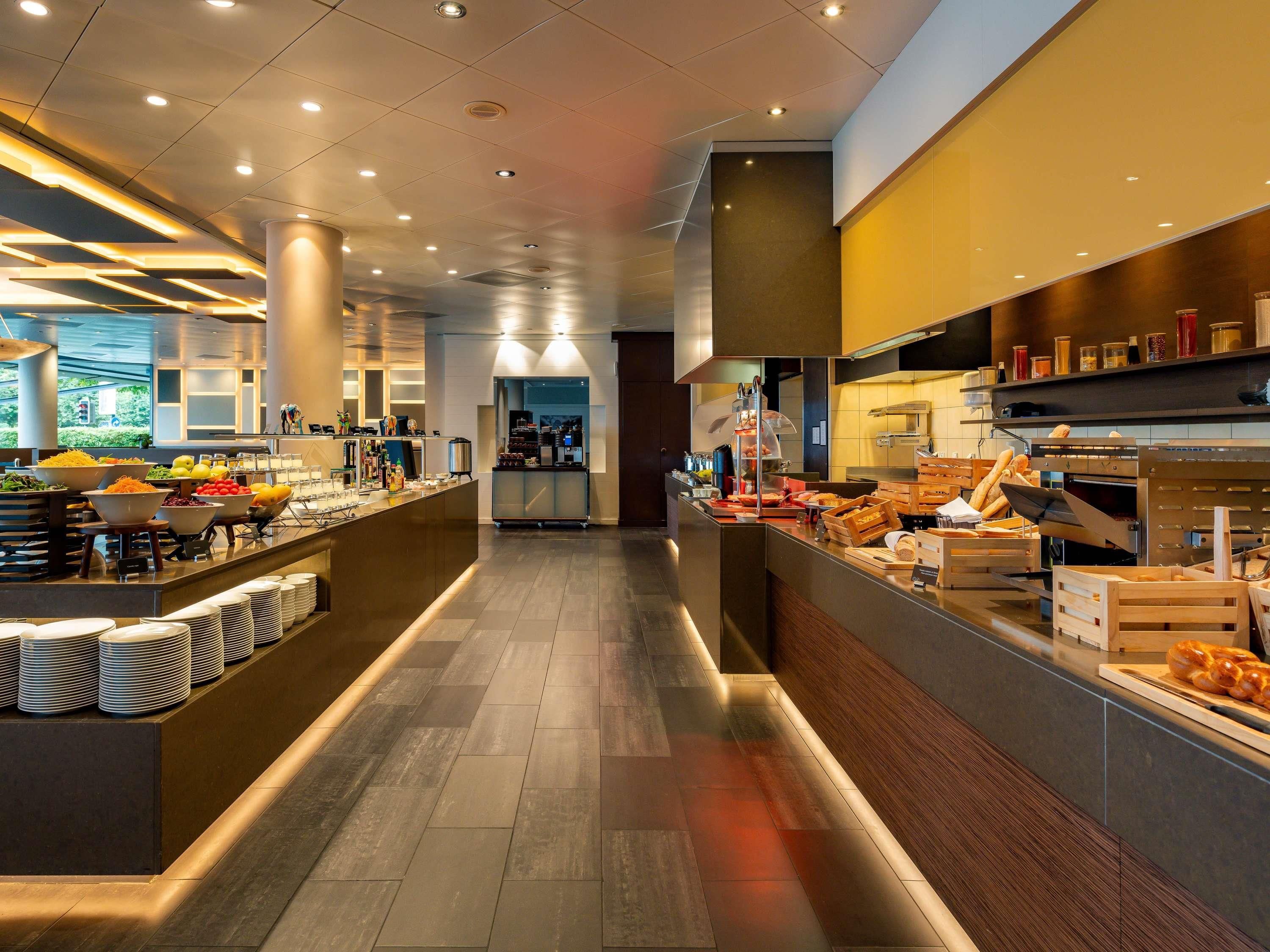 Um buffet de café da manhã moderno com diversas opções de comida e um canto para café.