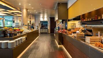 Um buffet de café da manhã moderno com diversas opções de comida e um canto para café.