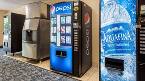 Espaço com máquinas automáticas, incluindo uma máquina de Pepsi, um dispensador de água e uma máquina de água Aquafina.
